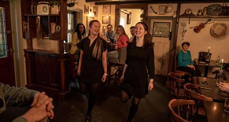 Two Irish dancers showing the group how to do Irish dancing as part of the Ceili & Craic experience at The Ponderosa.